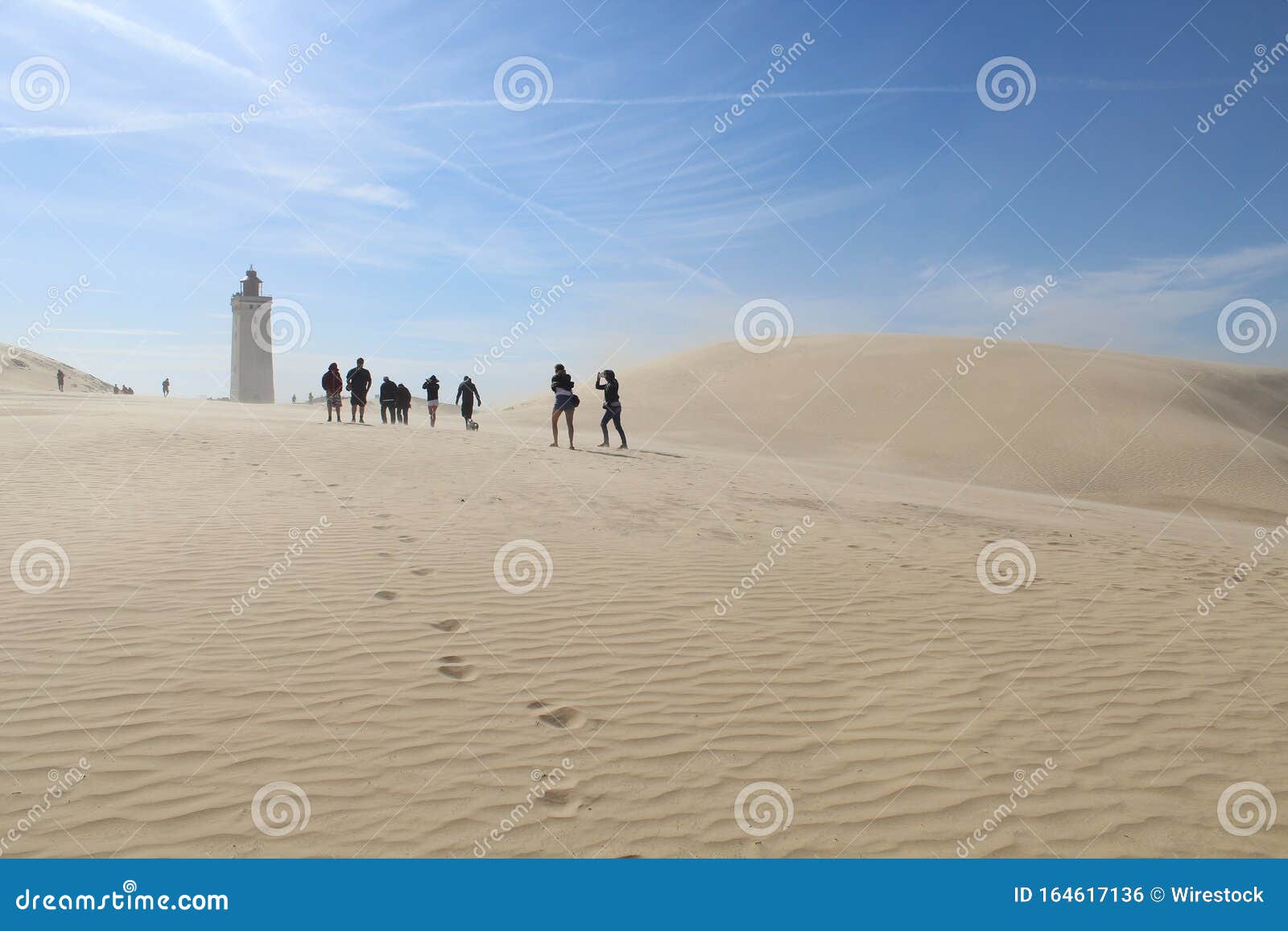 Low Angle Shot of a Group of Tourists Walking in the Desert Under the ...