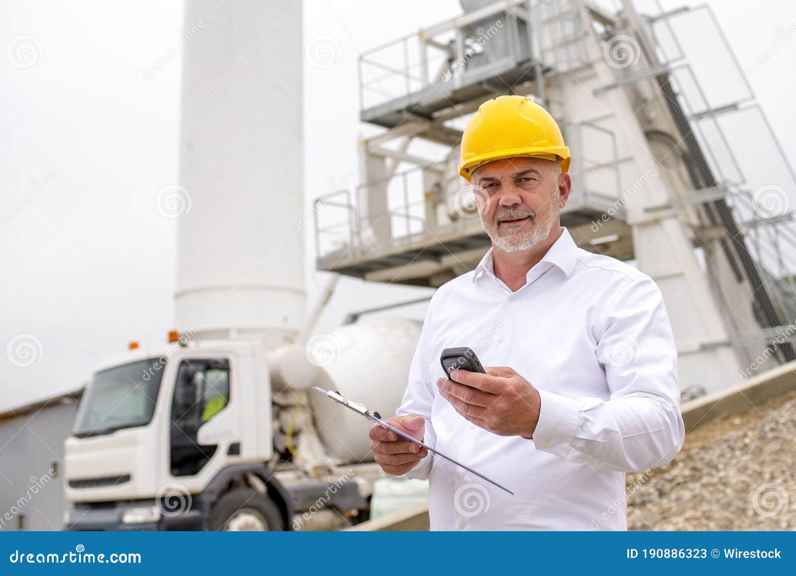 Low Angle Shot of a Male Engineer Looking at the Camera with a Building ...