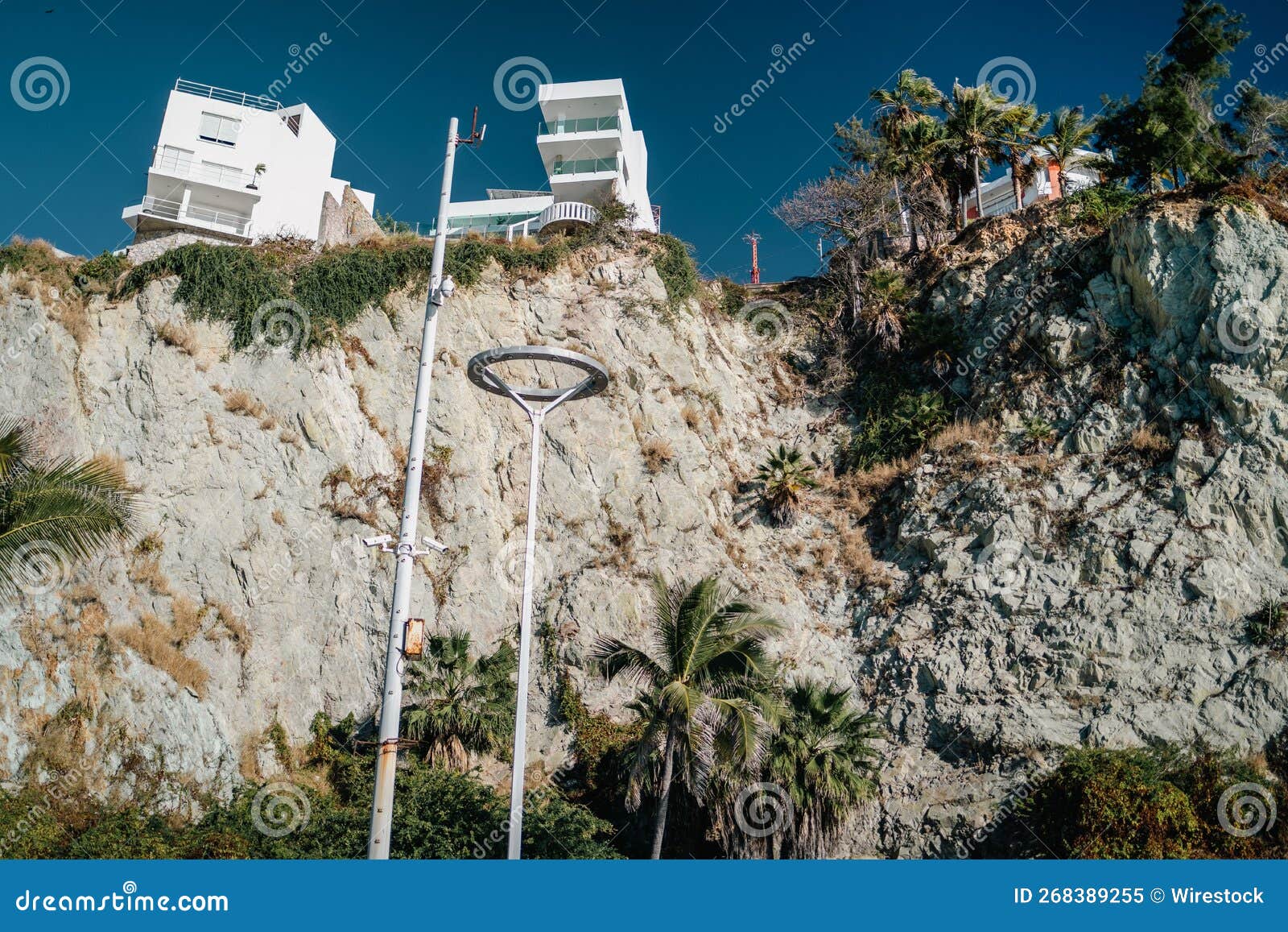 Low Angle Shot of Modern White Buildings on a Cliff and Green Palm ...