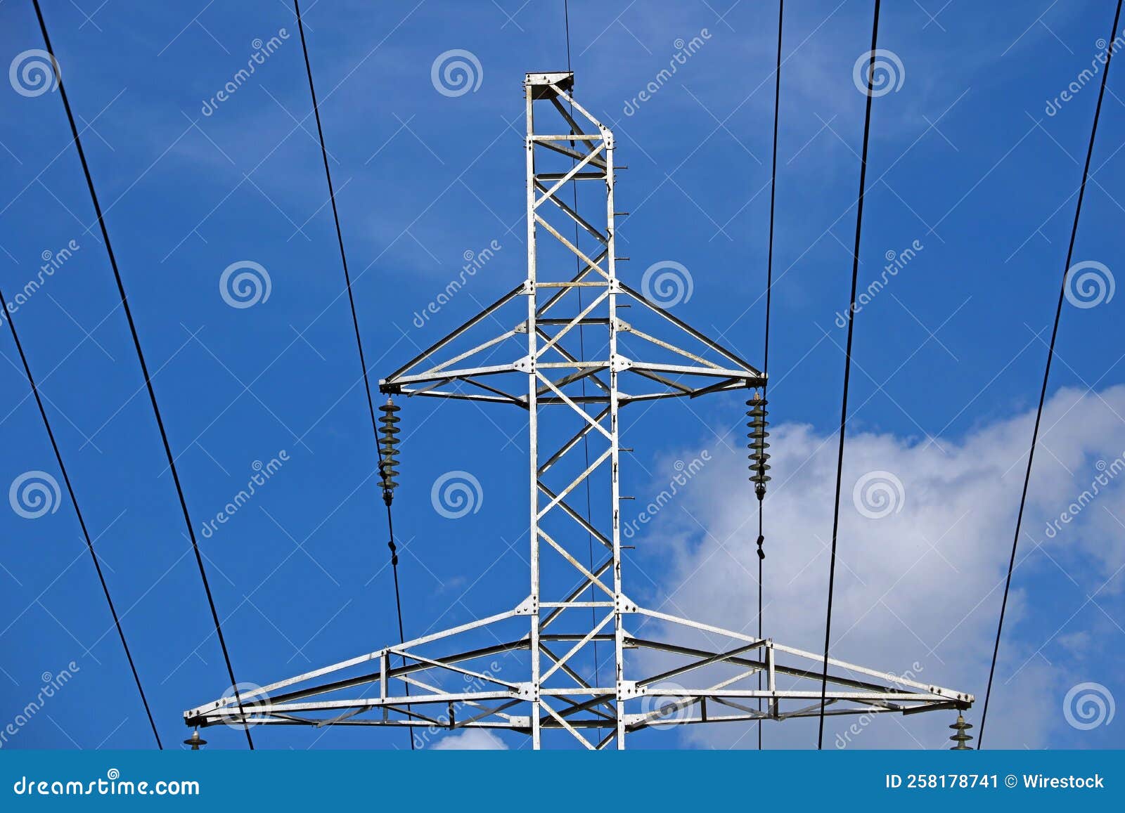 Low Angle Shot of a Pillar with High Voltage Power Lines Against a Blue ...
