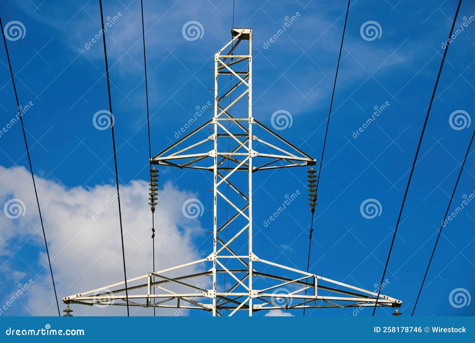 Low Angle Shot of a Pillar with High Voltage Power Lines Against a Blue ...