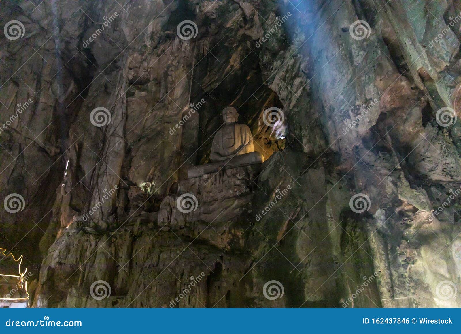 Low Angle Shot of a Pit Cave and a Buddha Statue with Sun Rays Falling ...
