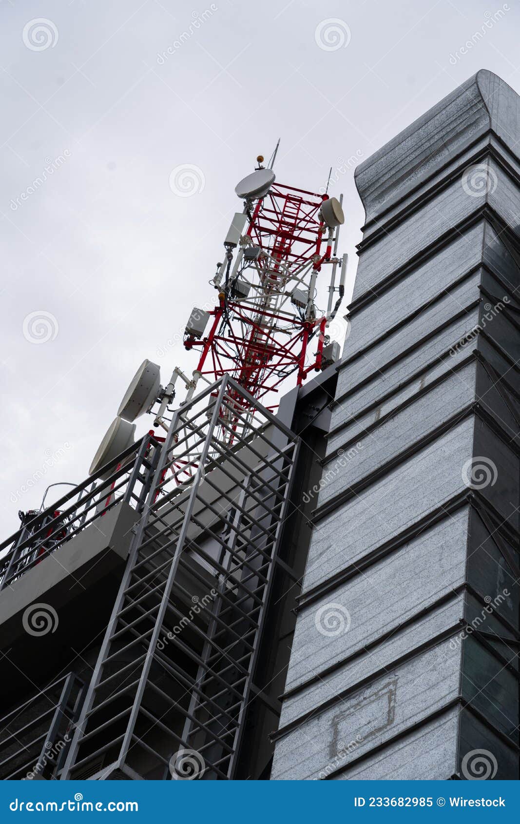 Low Angle Shot of a Telecom Tower on a Modern Building and a Gray Sky ...