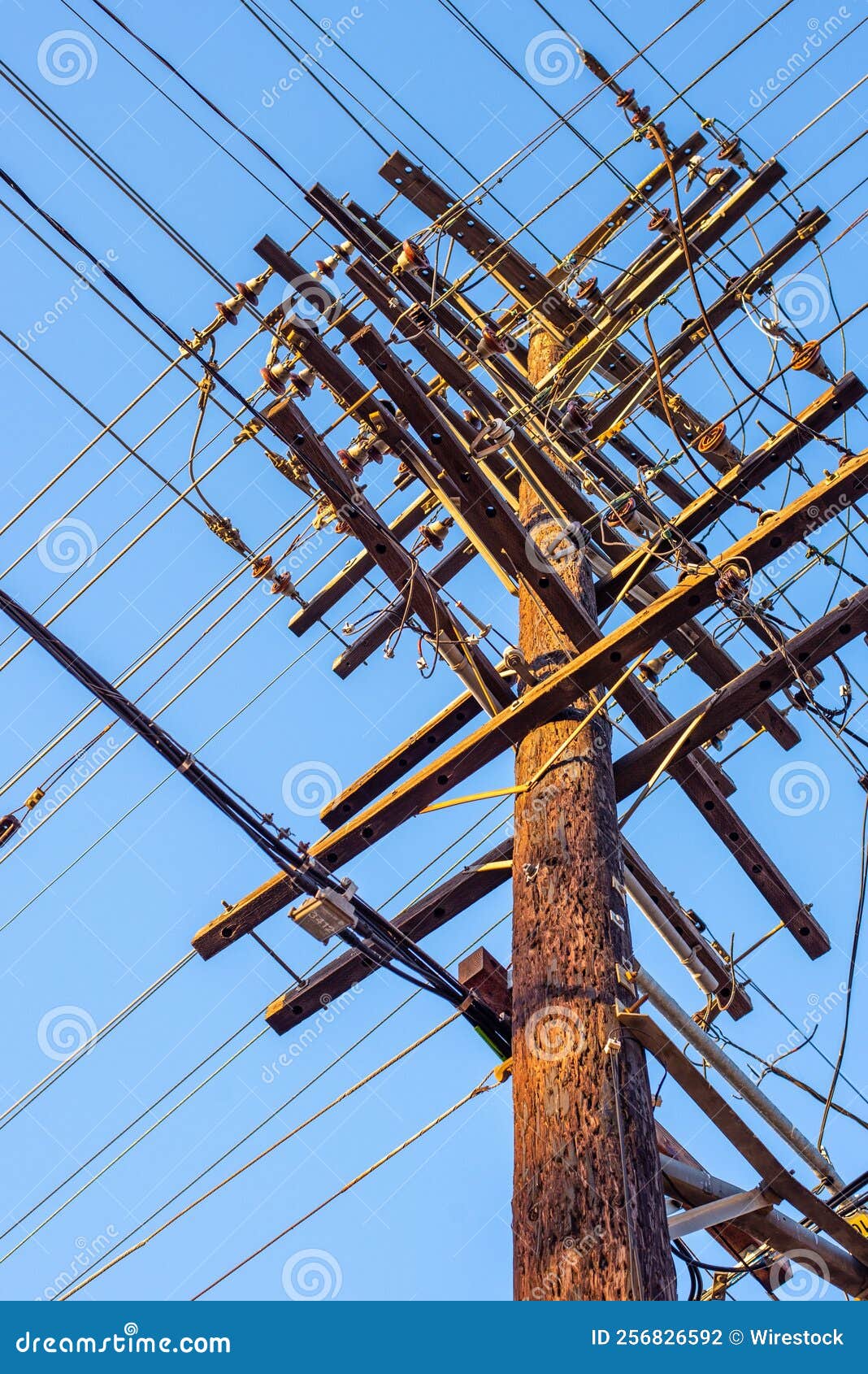 Low-angle Shot of a Utility Pole with Many Electric Wires Under a Blue ...