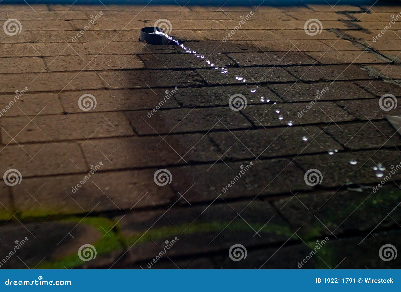 Low Angle Shot of Water Droplets Falling from a Pipe in a Stone Wall ...