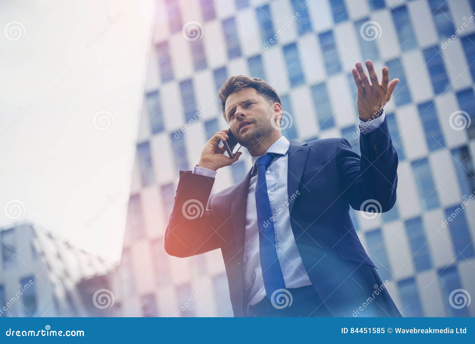 Low Angle View of Business Man Gesturing while Speaking on Mobile Phone ...