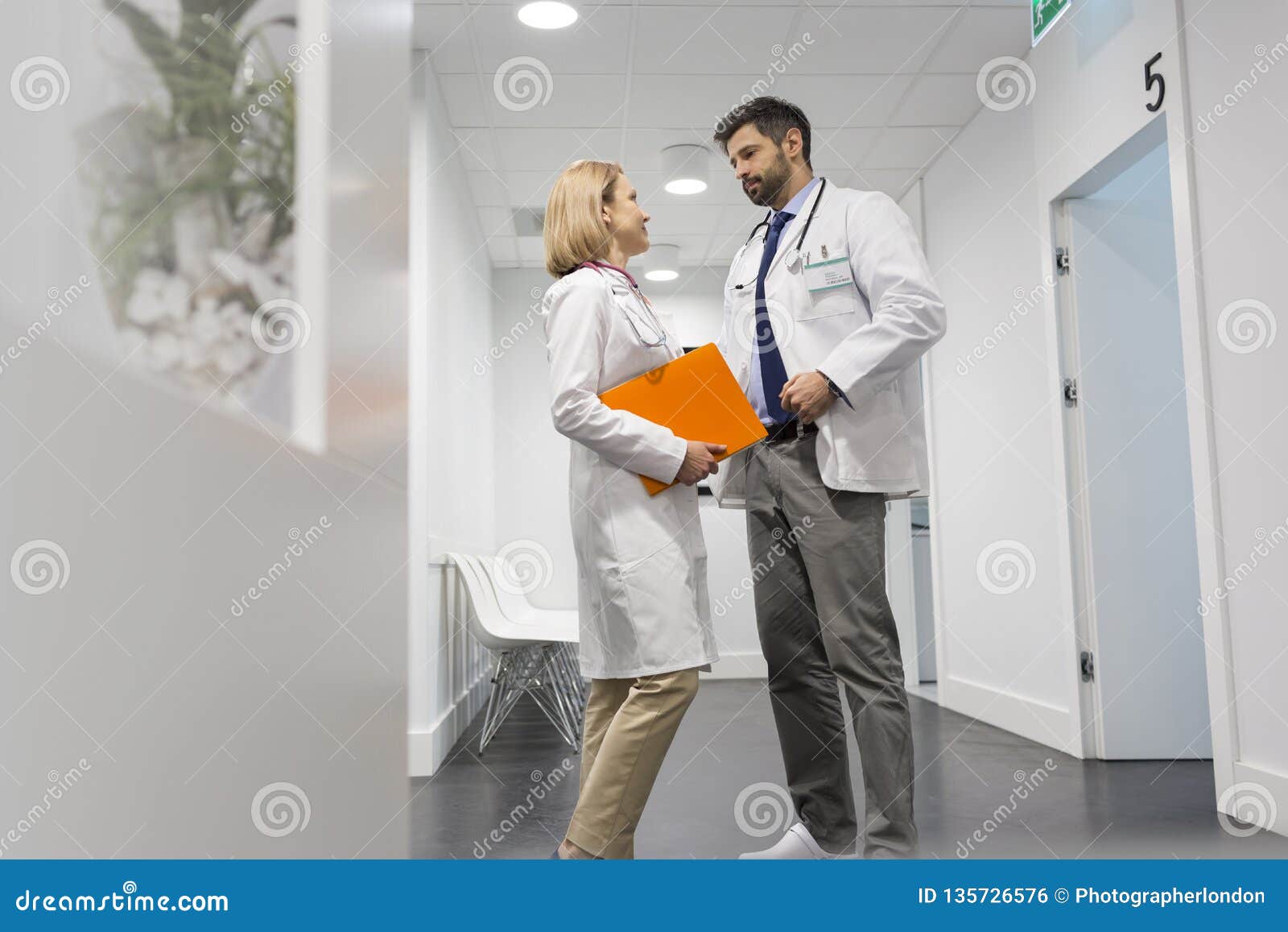 Low Angle View of Doctors Discussing in Corridor at Hospital Stock ...