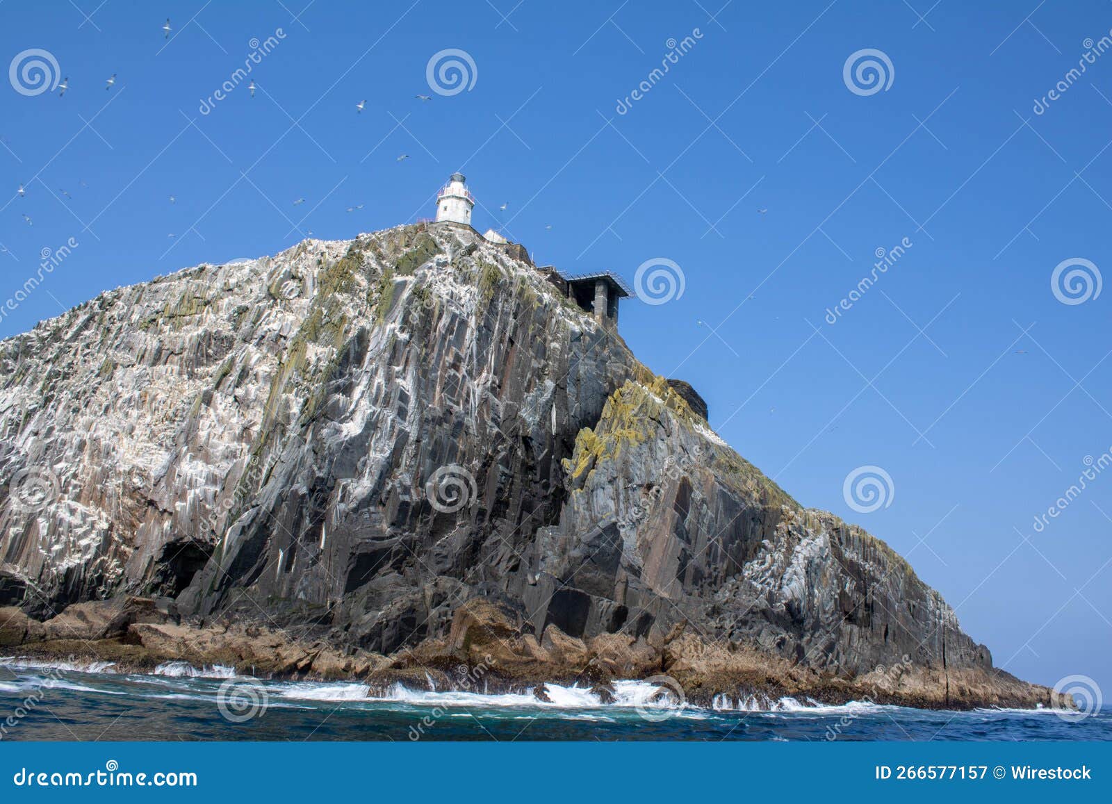 Low-angle View of a Lighthouse on Top of a Big Rock Cliff Island in the ...