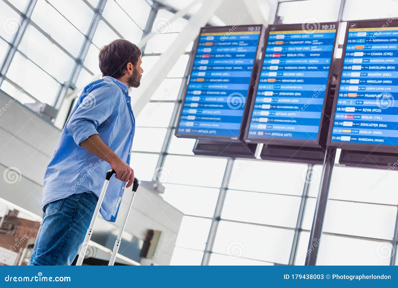 Low Angle View of Man Looking at His Flight on Screen in Airport Stock ...