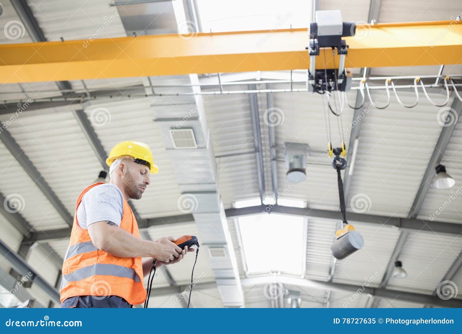 Low Angle View of Manual Worker Operating Crane Lifting Steel in ...