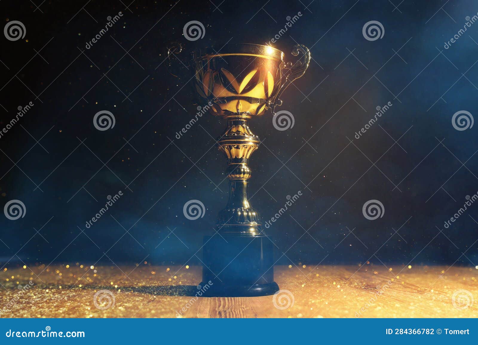 Low Key Image of Trophy Over Wooden Table and Dark Background, with ...