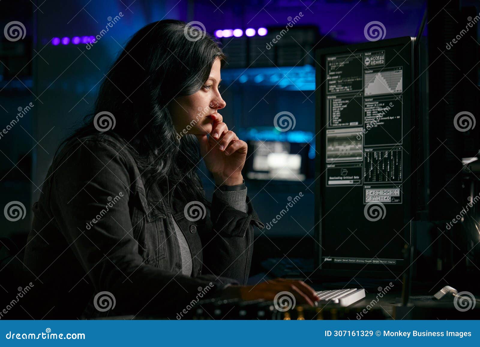 Low Key Lighting Shot of Female Computer Hacker Sitting in Front of ...