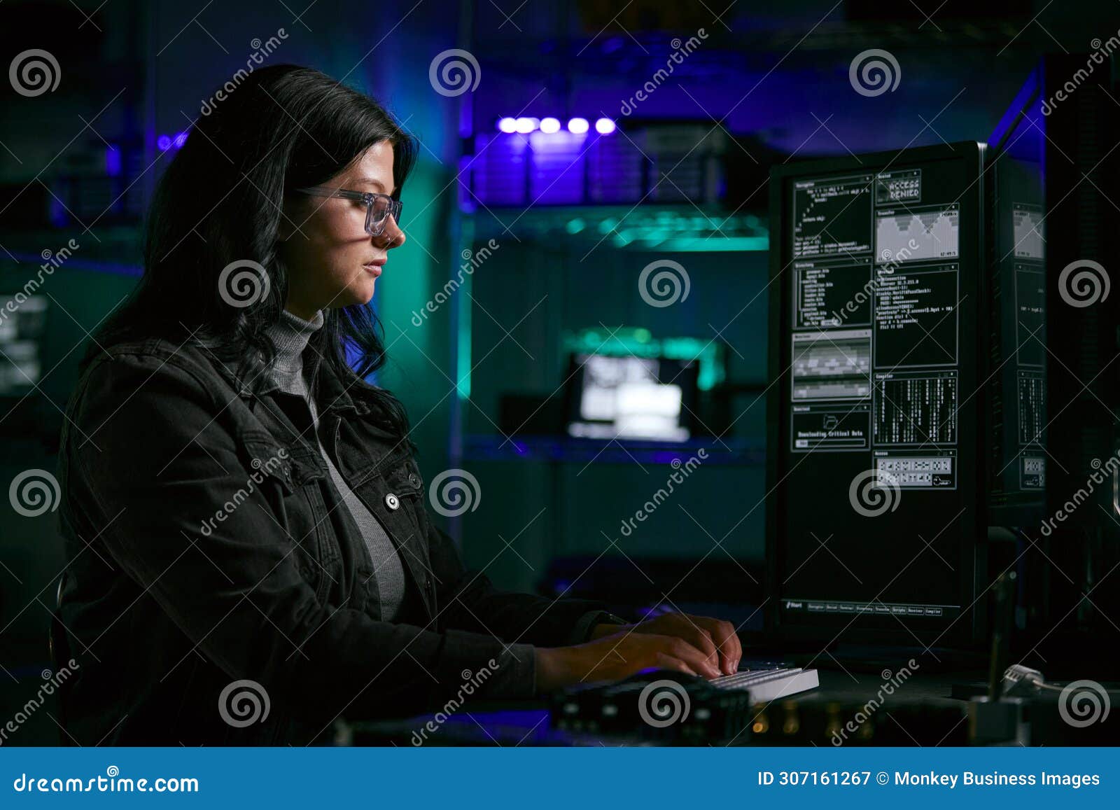 Low Key Lighting Shot of Female Computer Hacker Sitting in Front of ...