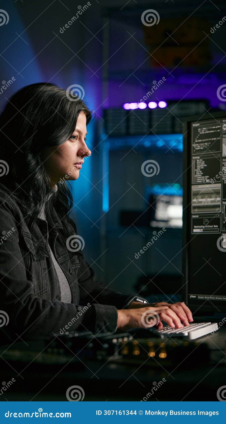 Low Key Lighting Shot of Female Computer Hacker Sitting in Front of ...