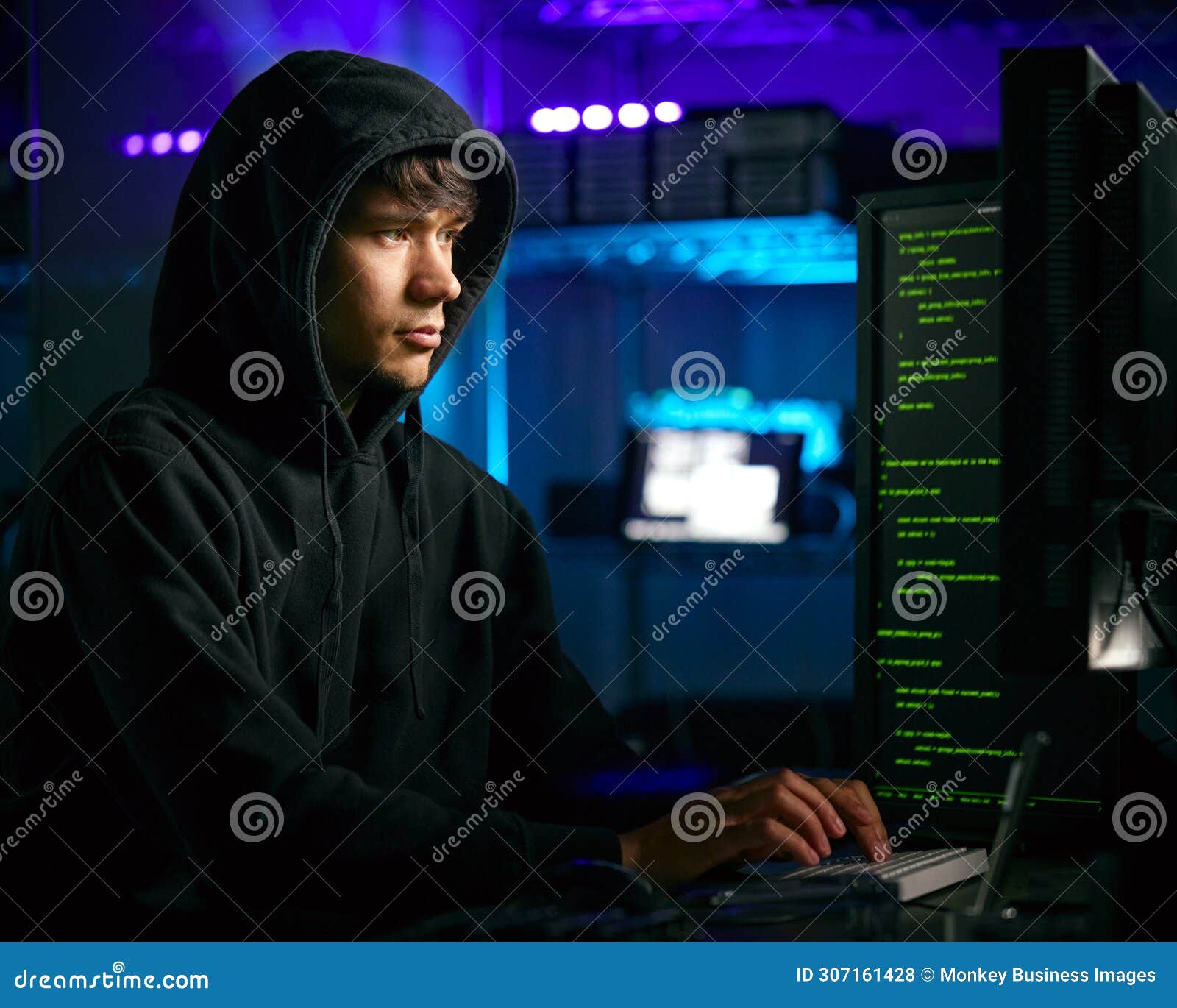 Low Key Lighting Shot of Male Computer Hacker Sitting in Front of ...