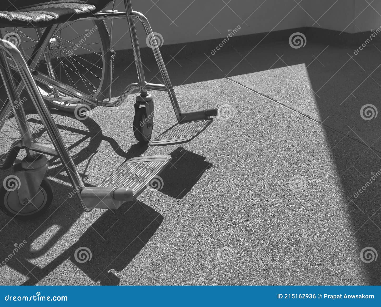 Empty Wheelchair on Pavement with Sunlight and Shadow on Surface in ...