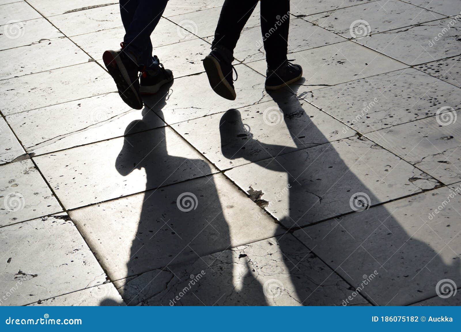 Low Section of Legs and Their Shadows on Pavement Stock Photo - Image ...