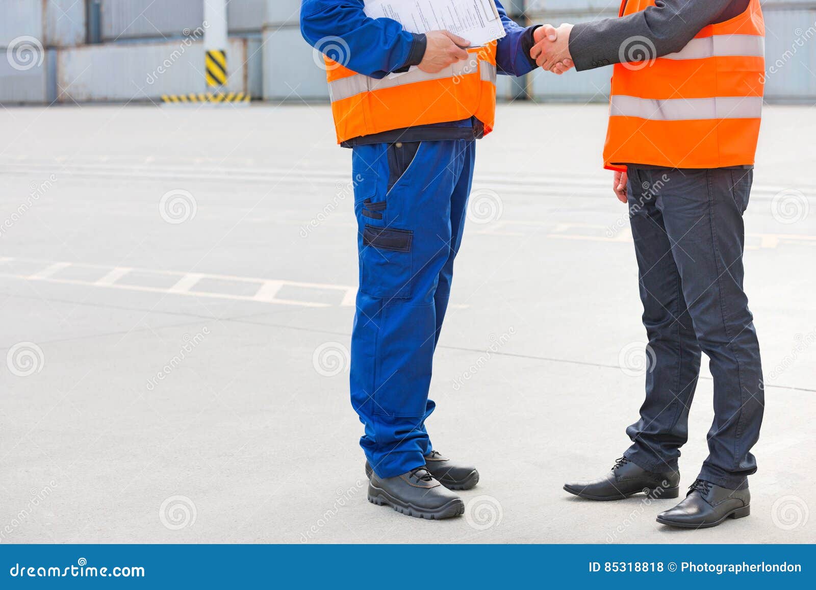 Low Section of Workers Shaking Hands in Shipping Yard Stock Photo ...