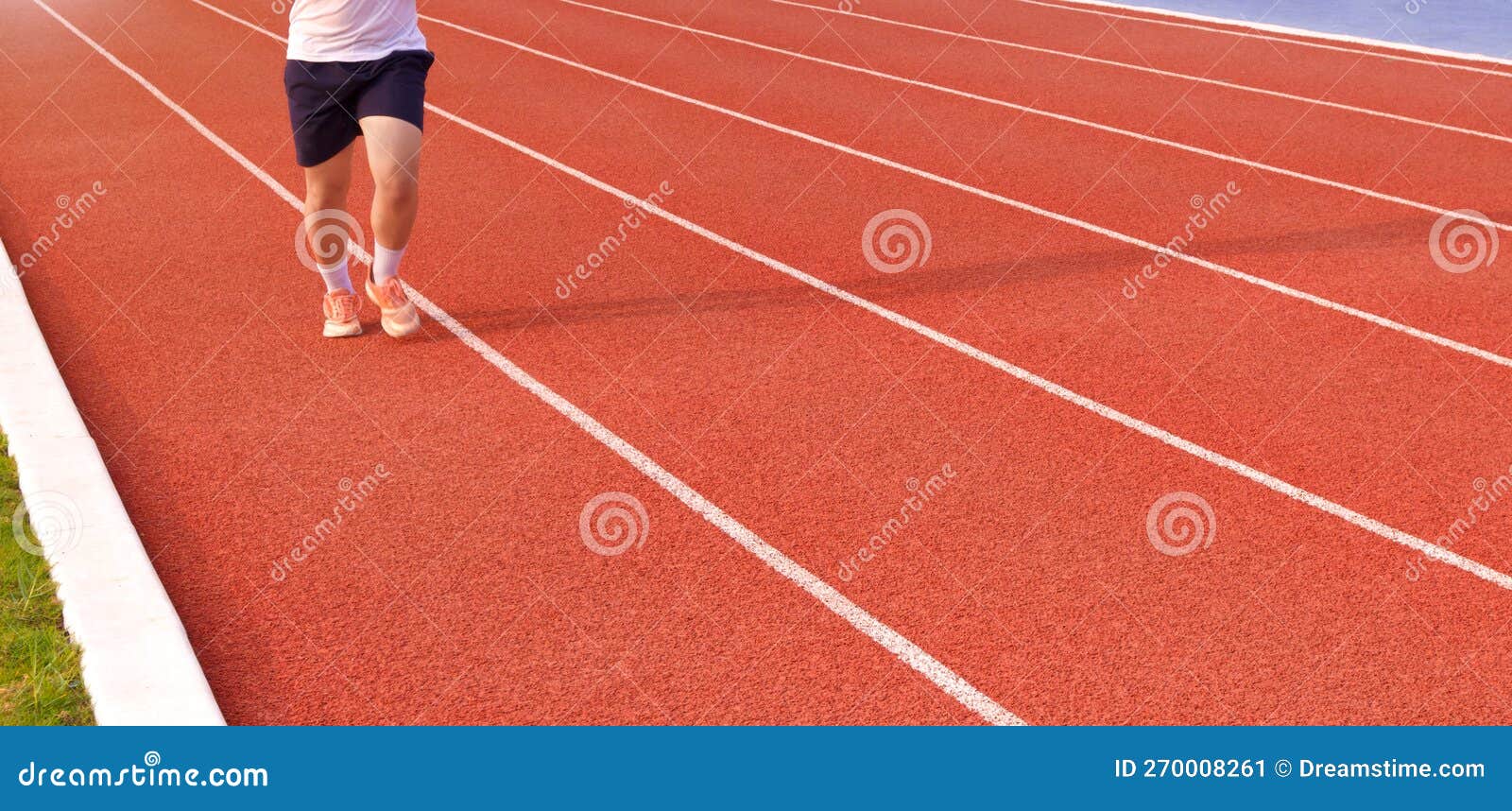 Low Section of Young Man Jogging on Running Track in Outdoors Stadium ...