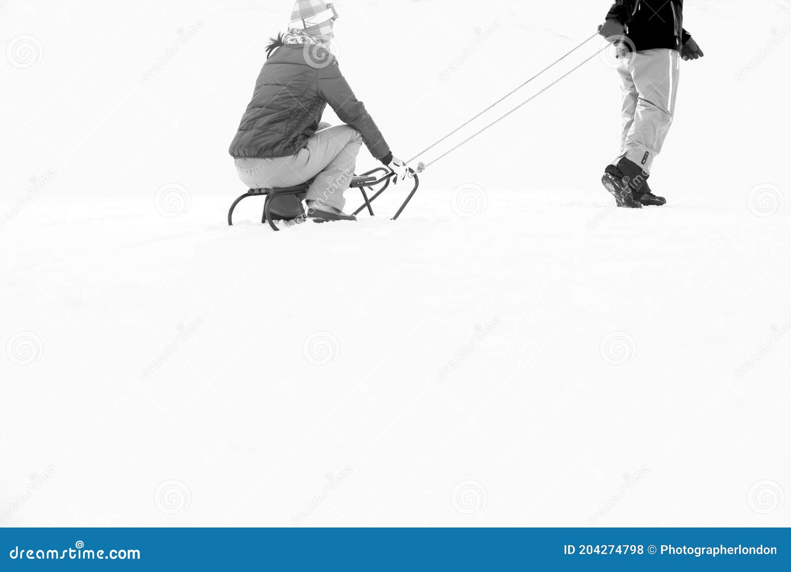 Low Section of Young Man Pulling Woman on Sled Stock Photo - Image of ...