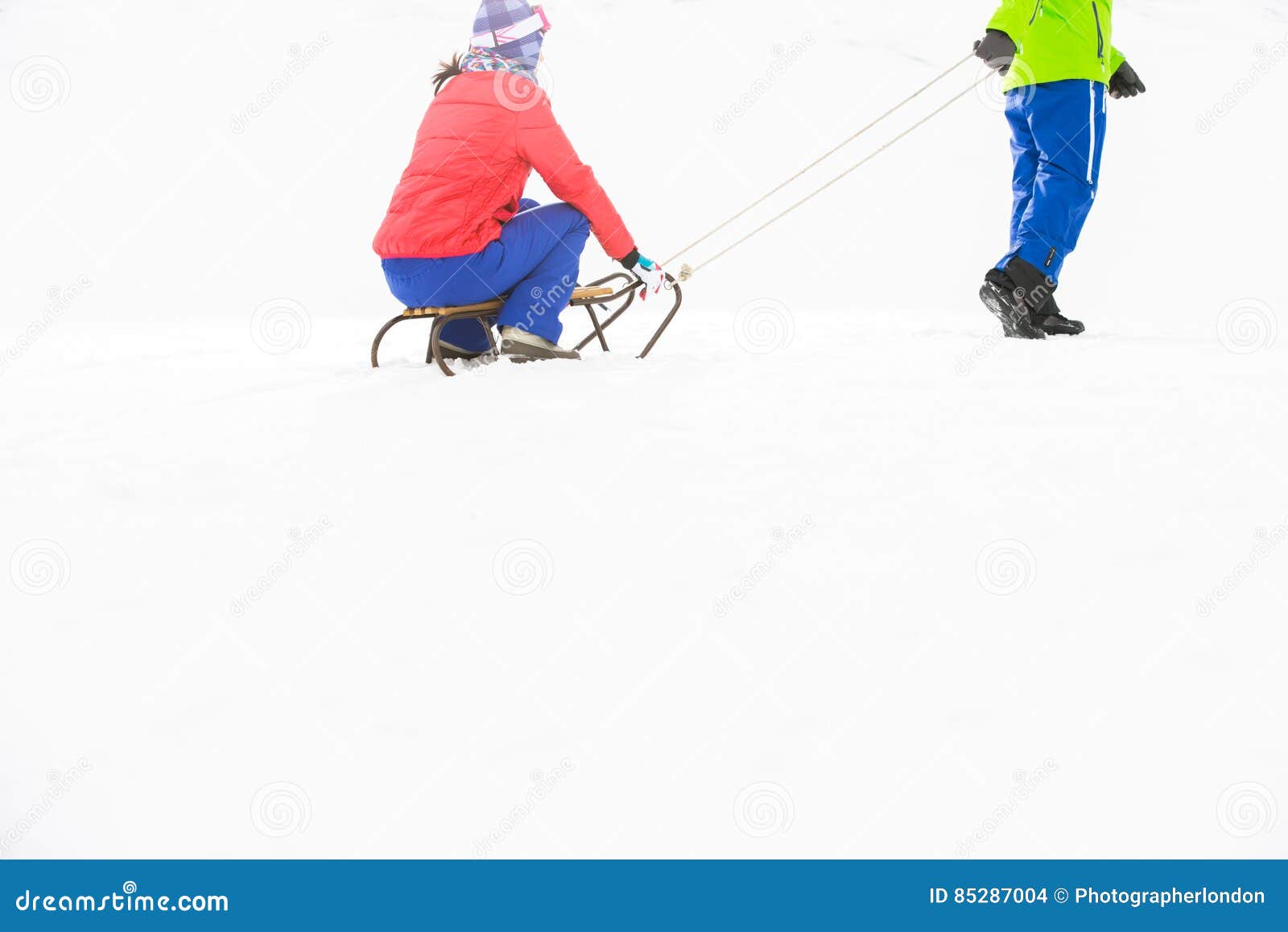 Low Section of Young Man Pulling Woman on Sled Stock Photo - Image of ...