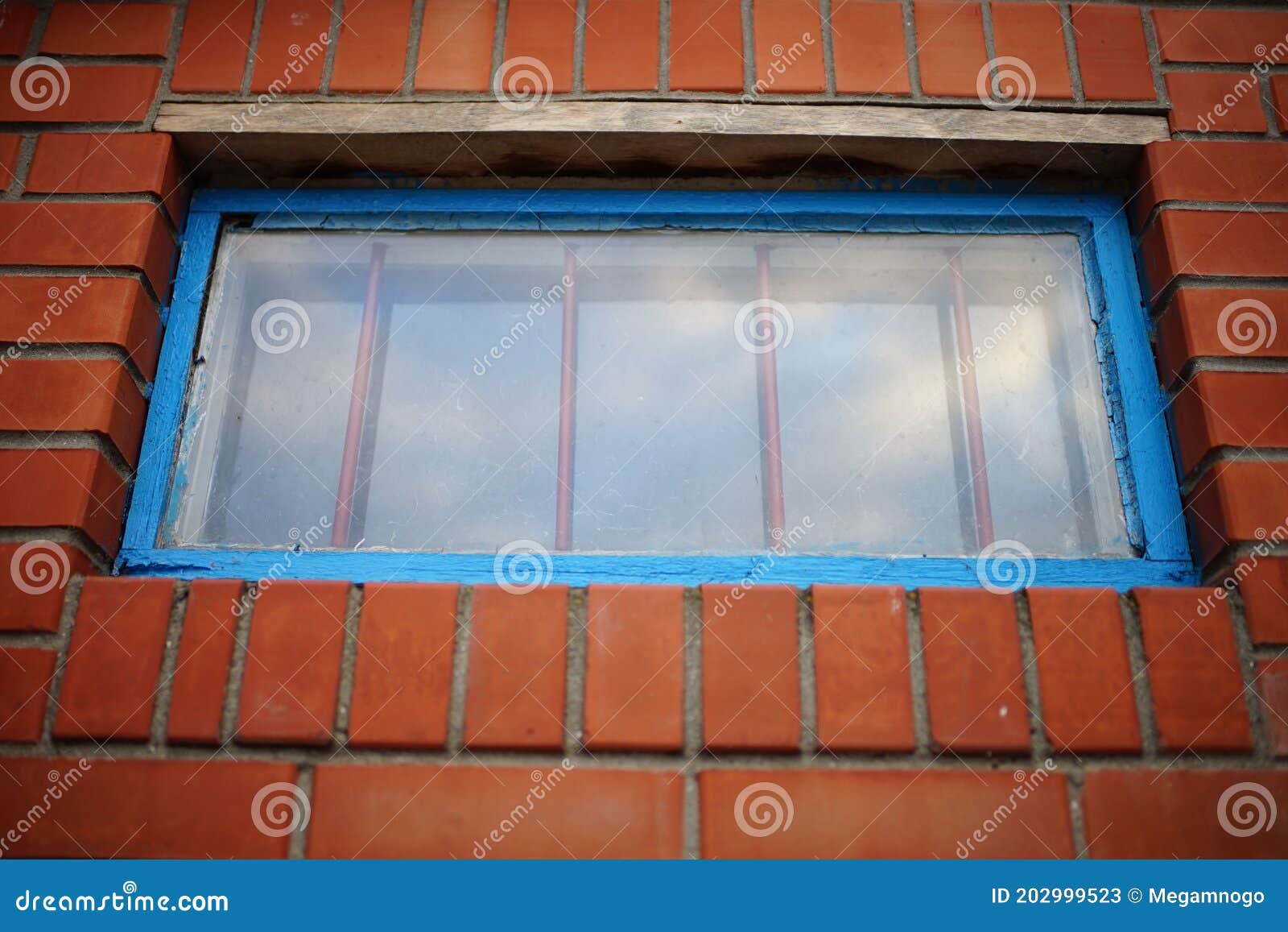Low Window with Blue Frame and Iron Grating in a Brick Building Stock ...