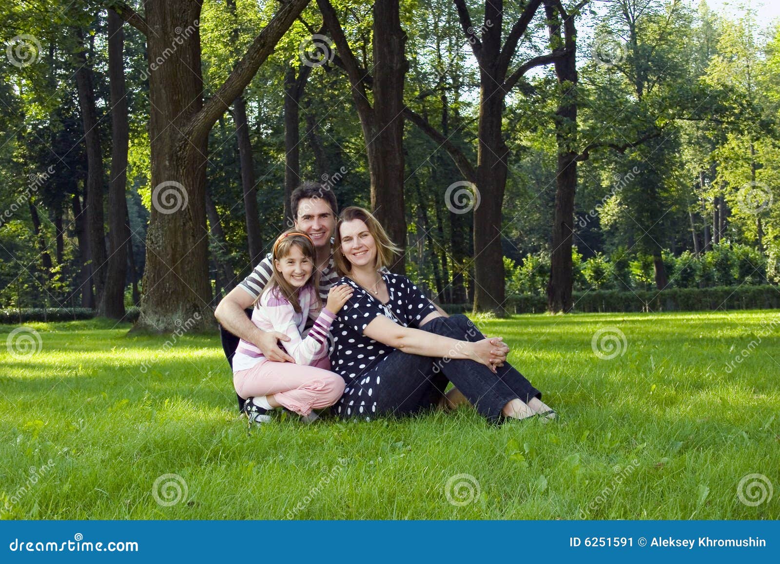 Lucky family on lawn stock image. Image of three, smiling - 6251591