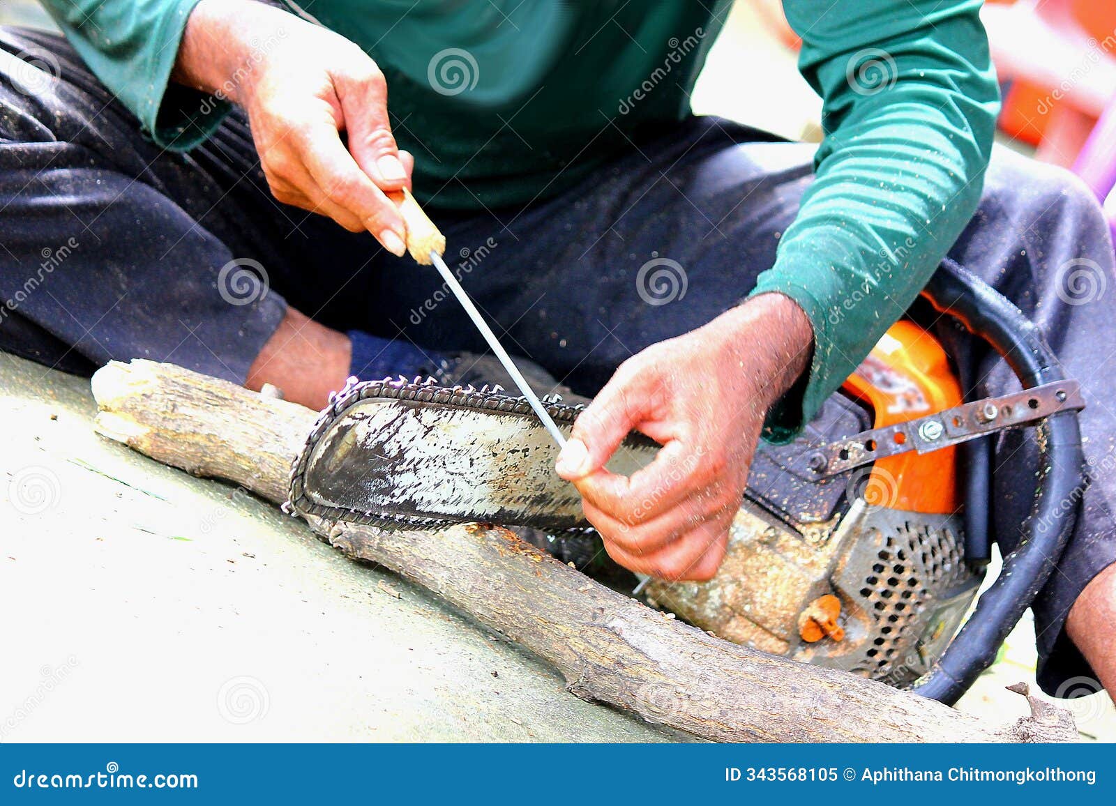 Lumberman Using Round File or Rat Tail File is Sharpening a Chainsaw ...