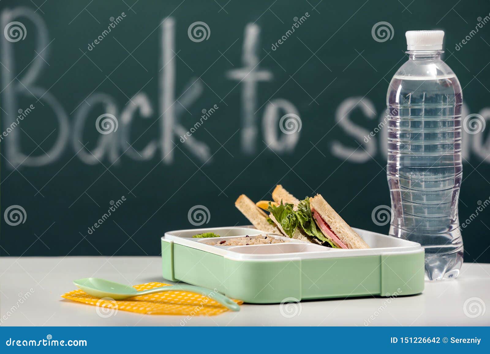 Lunch Box with Appetizing Food and Bottle of Water on White Table in ...