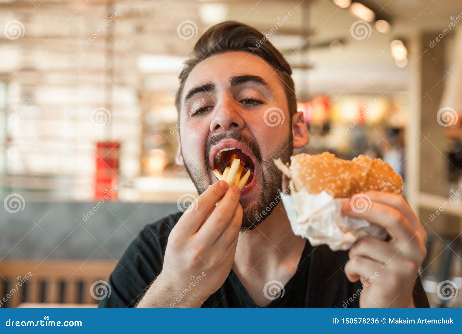 Lunch at the Cafe. a Man Eats French Fries and Keeps a Burger Stock ...
