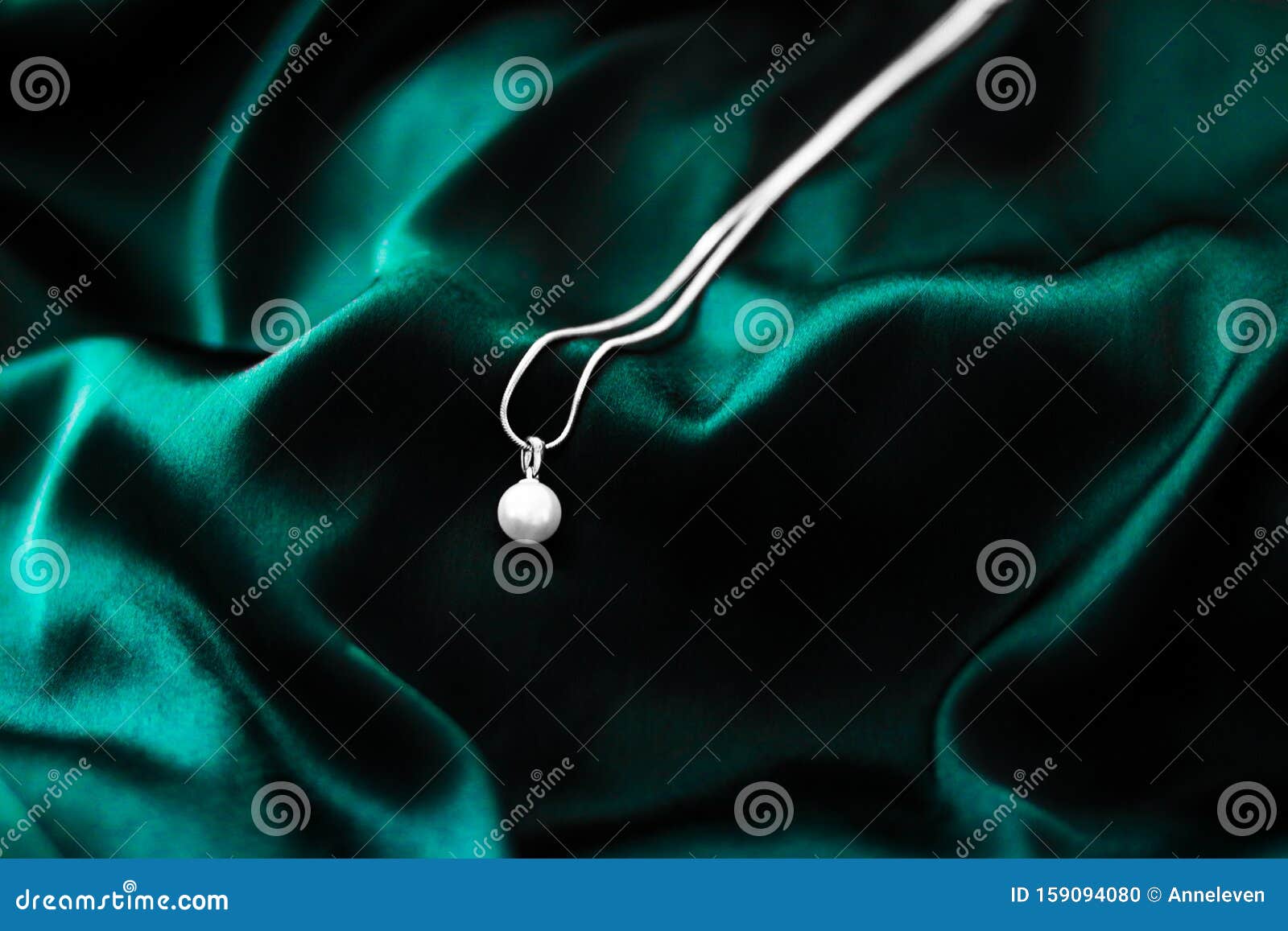Luxury White Gold Pearl Necklace On Dark Emerald Green Silk Background