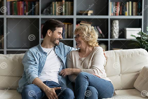 Lycklig Mogen Kvinna Och Ung Man Som Pratar På Soffan Fotografering För