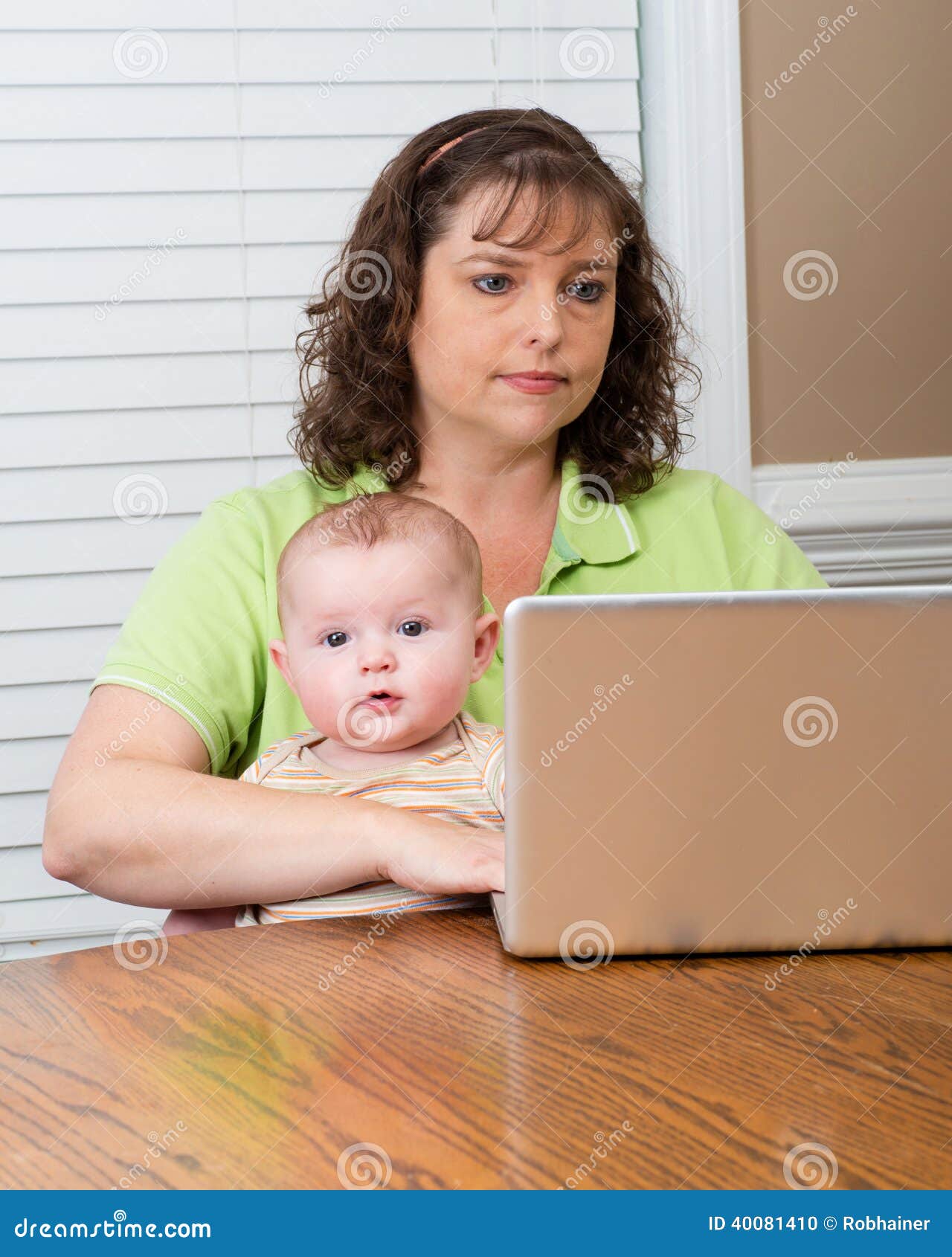 Mãe Que Guarda O Bebê Ao Trabalhar No Computador Foto de Stock - Imagem ...