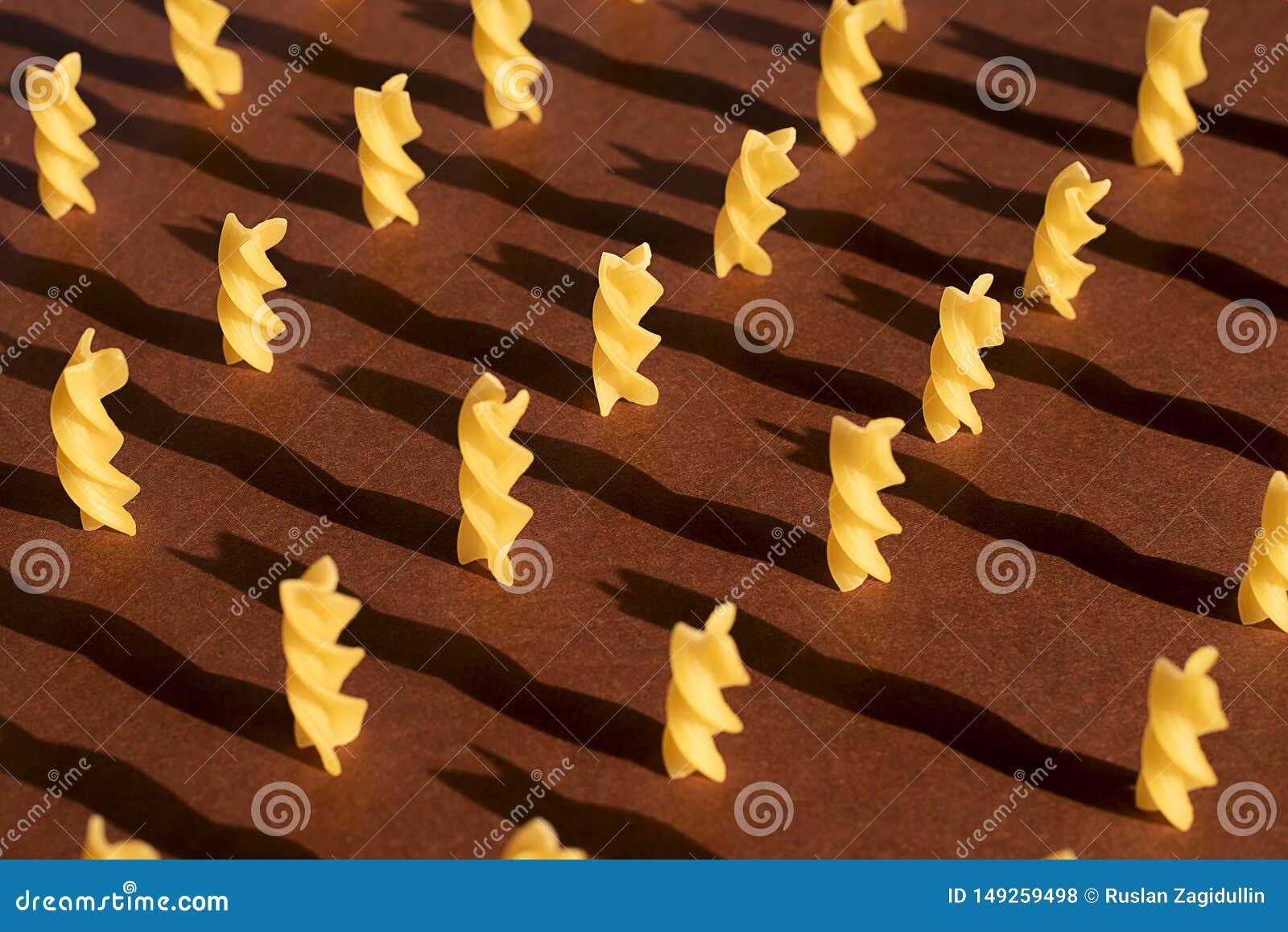 Macaroni in the Form of Yellow Spirals on a Brown Background Lined Up ...
