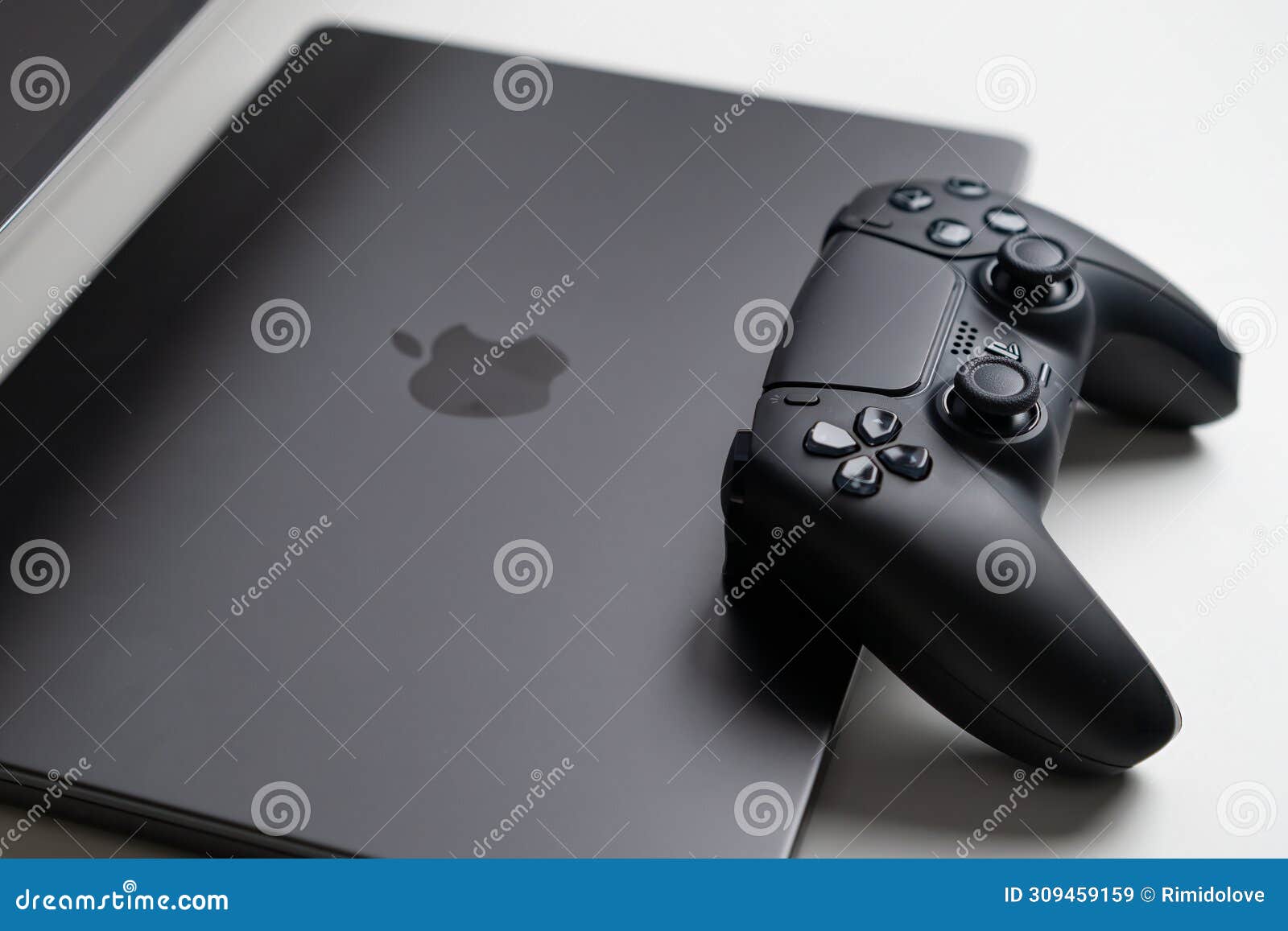 MacBook Pro and Video Game Controller on the White Table Editorial ...