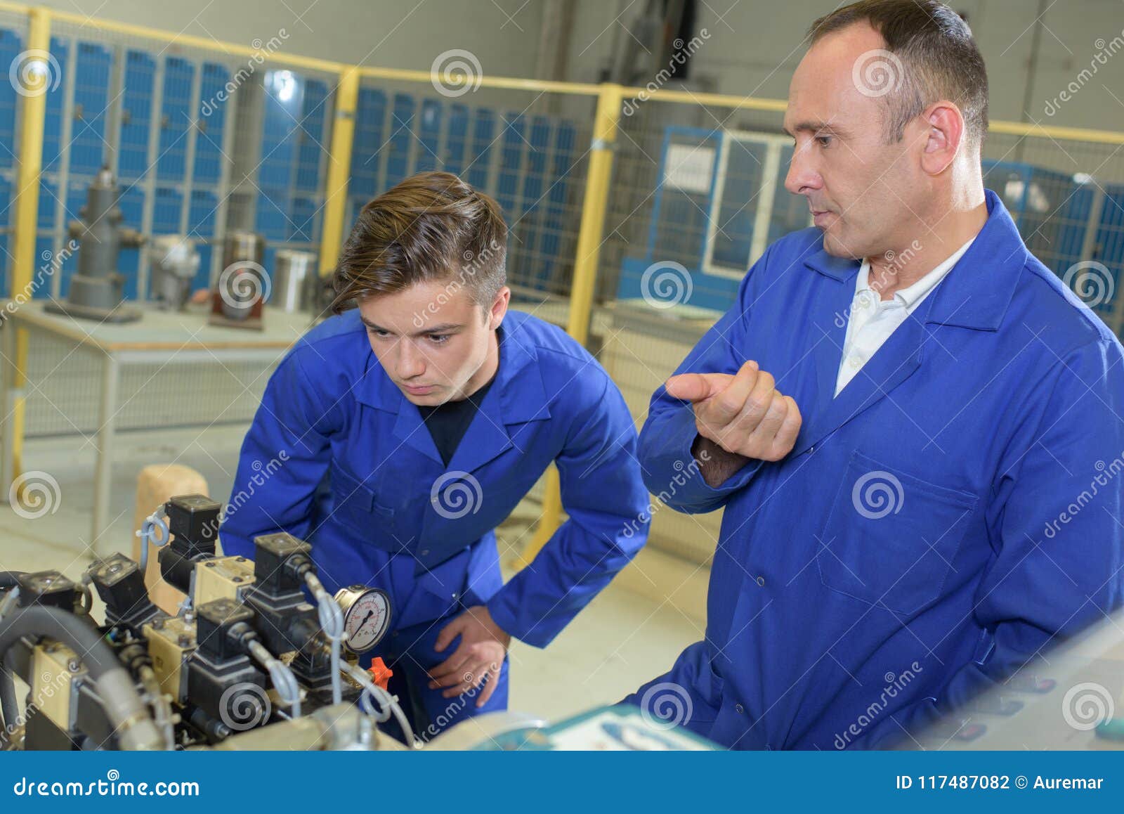 Machinist and His Apprentice Stock Photo - Image of assembler, machine ...