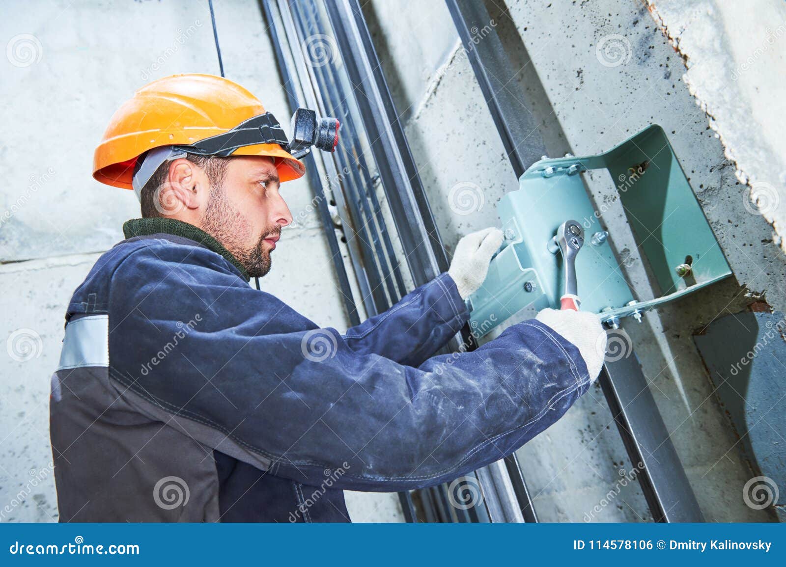 Machinist With Spanner Adjusting Lift Mechanism In Elevator Shaft ...