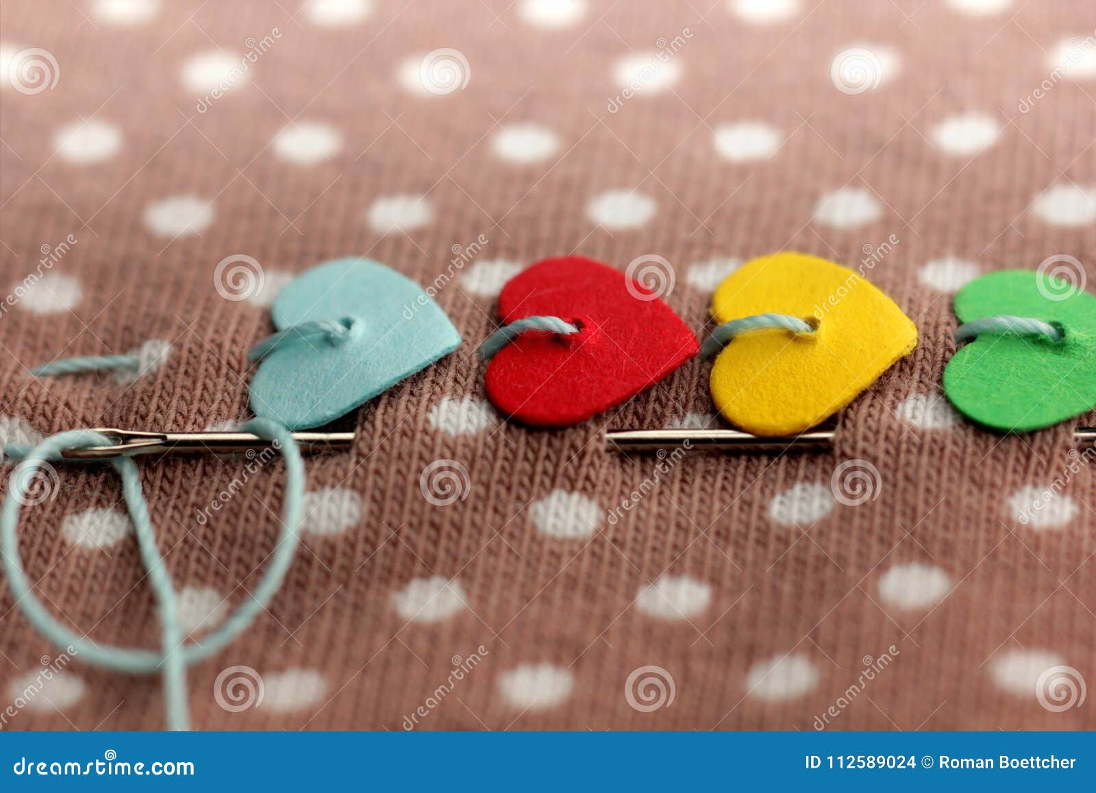 Macro of Colorful Hearts Stitched on Dotted Fabric with Needle and ...