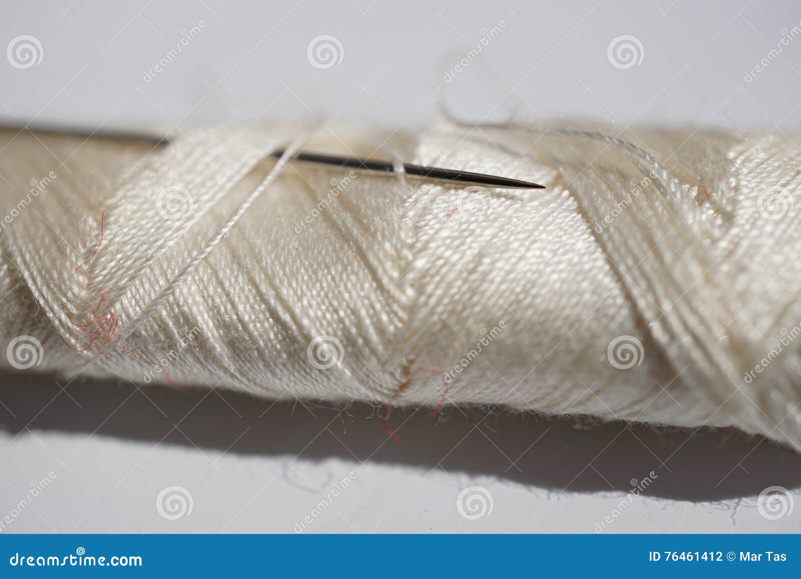 Macro Detail of a Silver Sharp Needle Inserted in the Spool of White ...