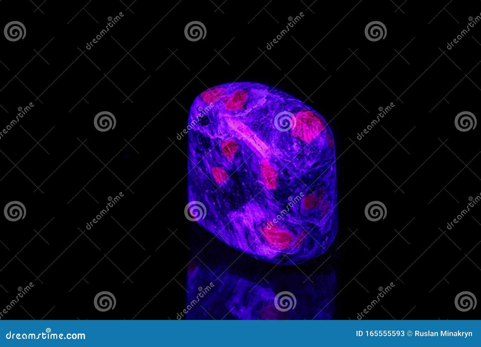 Macro Mineral Stone Ruby Under Ultraviolet Light on a Black Background ...