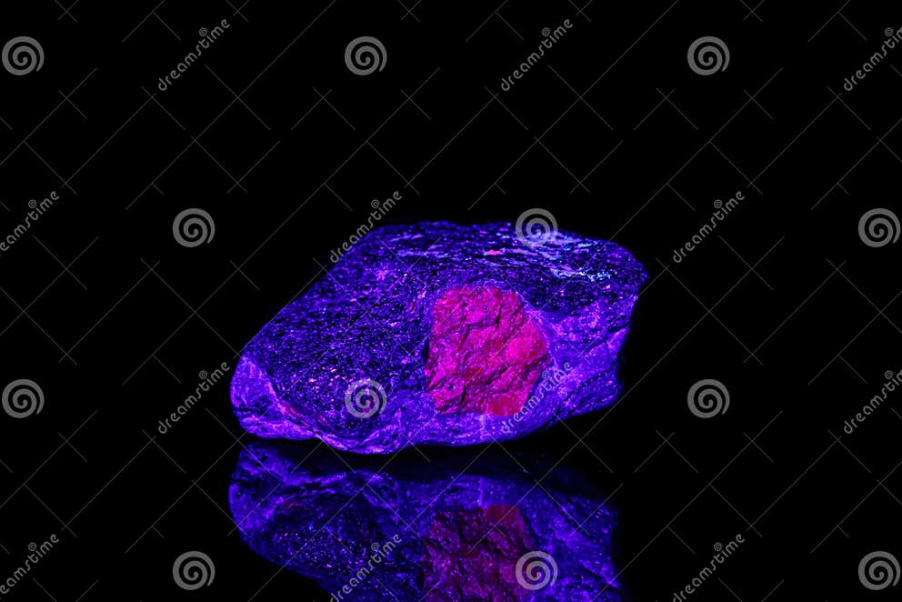 Macro Mineral Stone Ruby Under Ultraviolet Light on a Black Background ...