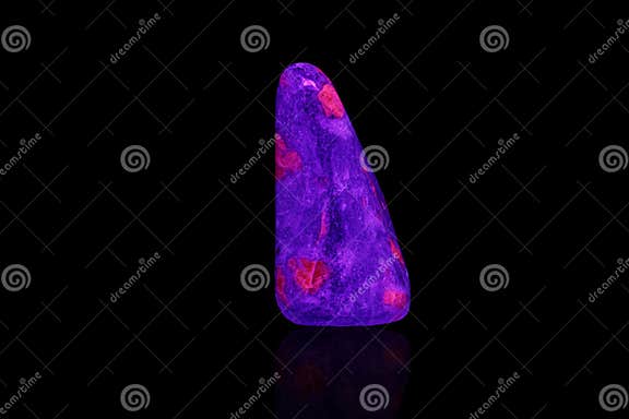 Macro Mineral Stone Ruby Under Ultraviolet Light on a Black Background ...