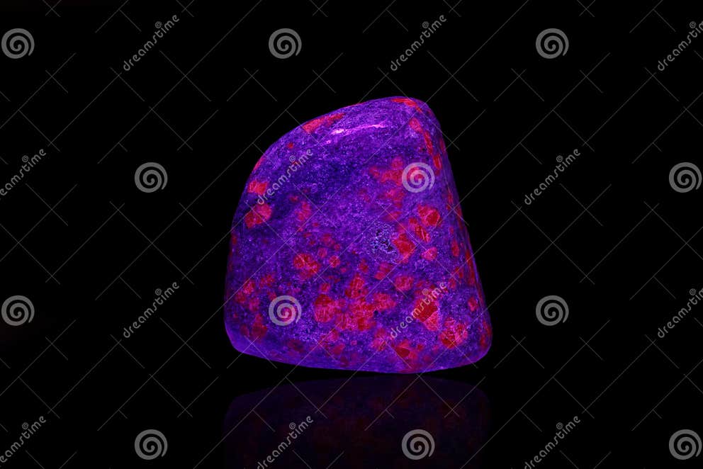 Macro Mineral Stone Ruby Under Ultraviolet Light on a Black Background ...