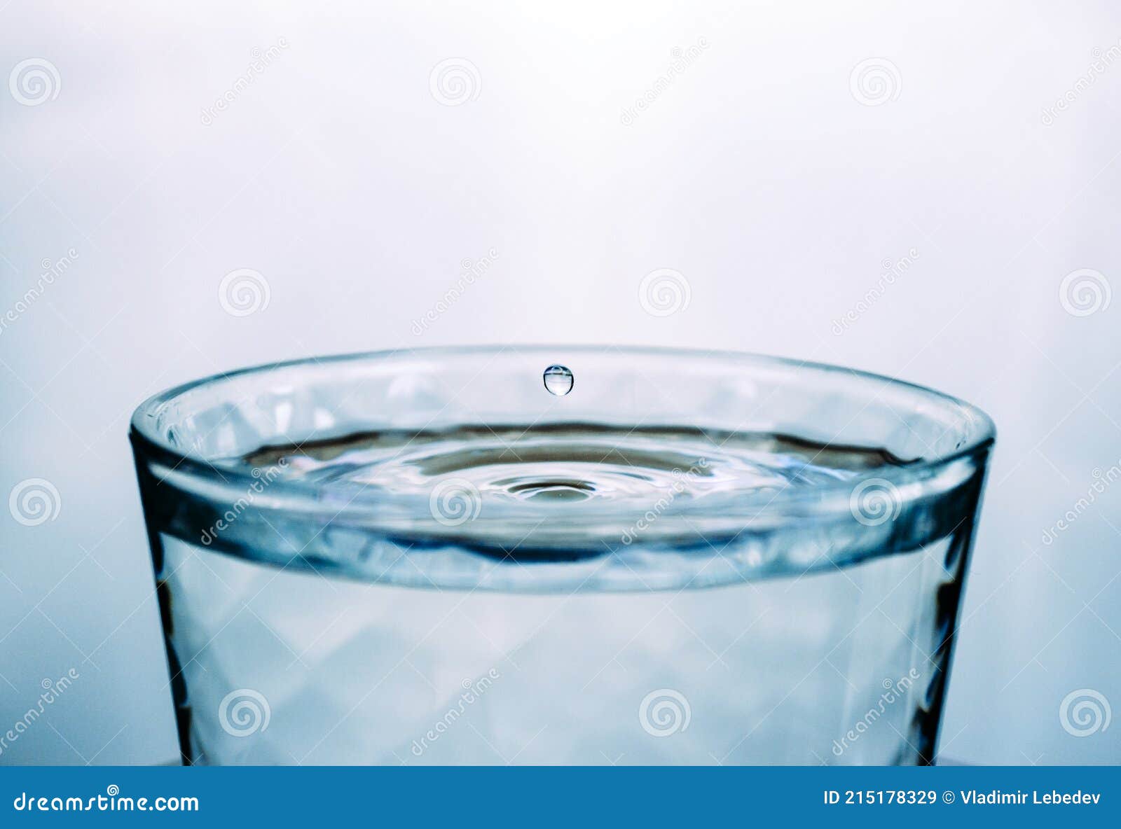 Macro Shot of a Drop of Water Falling into a Glass Cup with Drinking ...