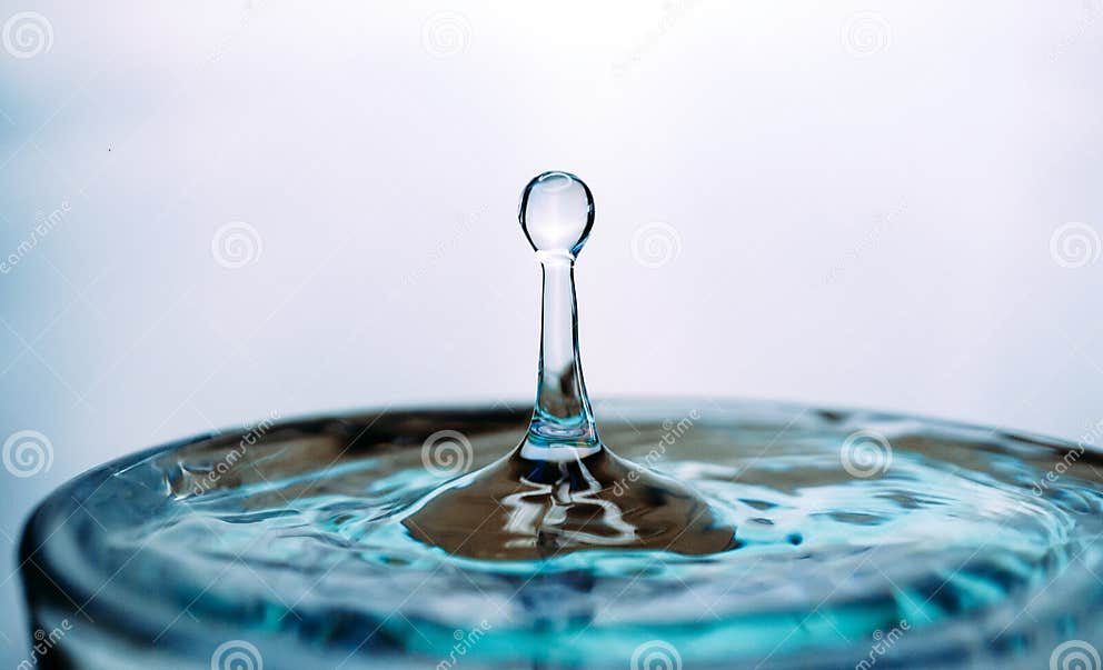 Macro Shot of a Drop of Water Falling into a Glass Cup with Drinking ...
