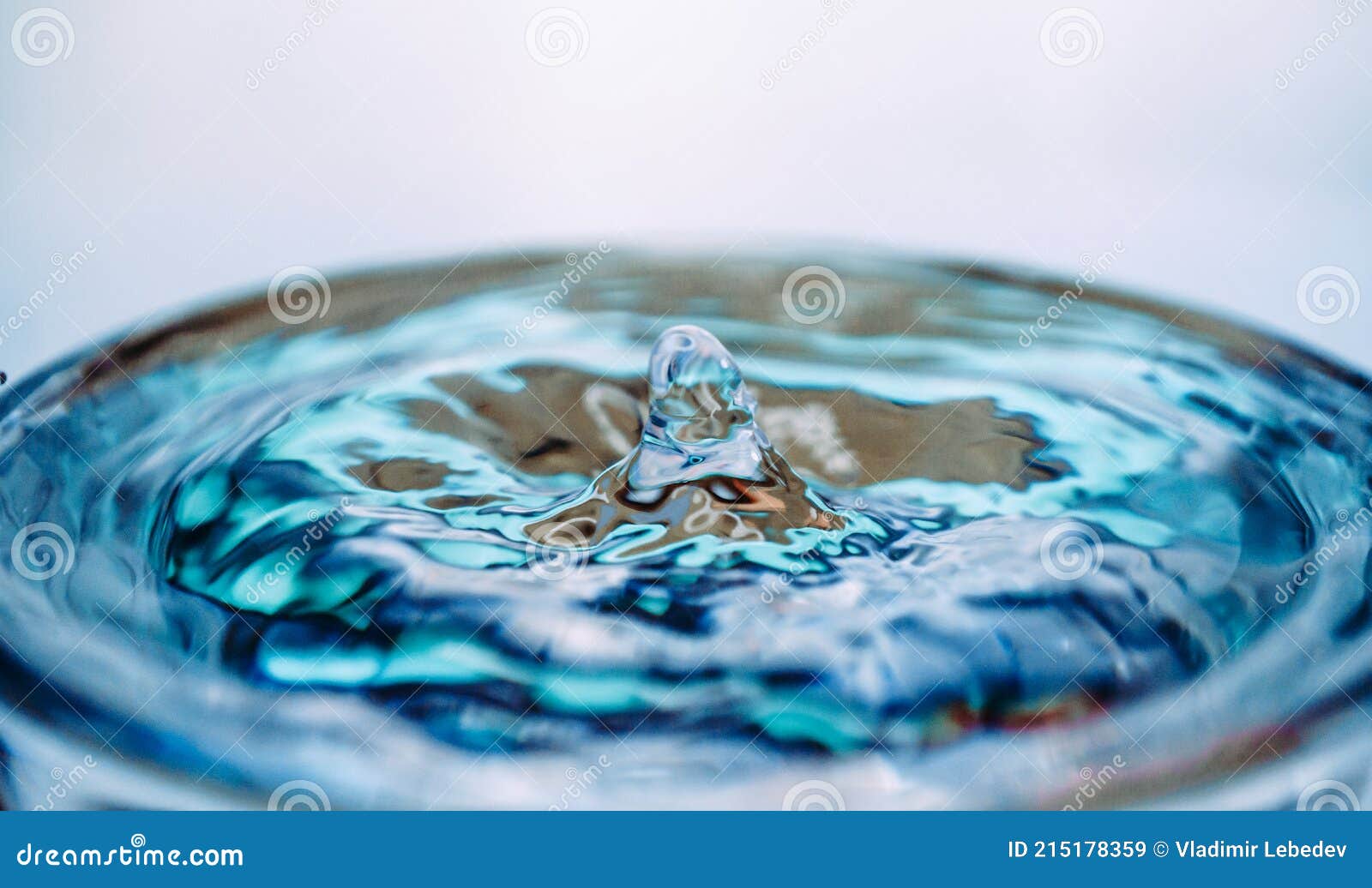 Macro Shot of a Drop of Water Falling into a Glass Cup with Drinking ...
