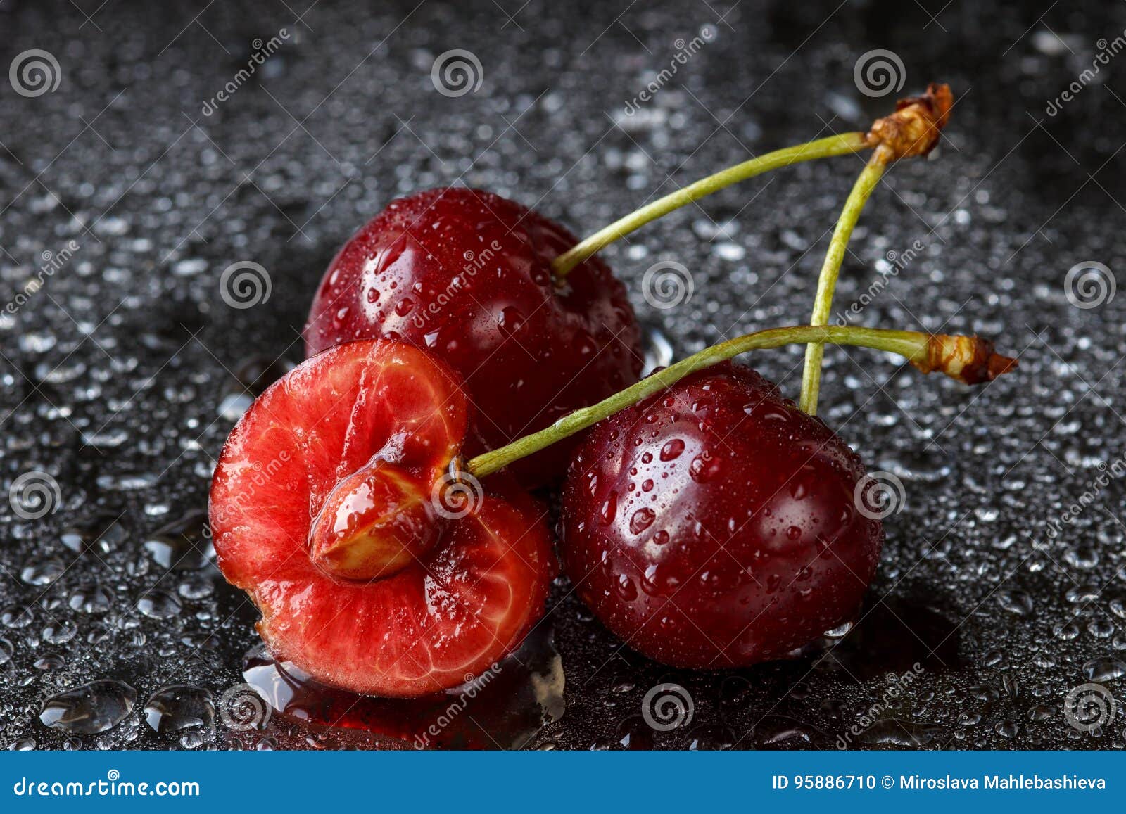 Macro of Two and Half Sliced Cherries on a Black Background with Water ...