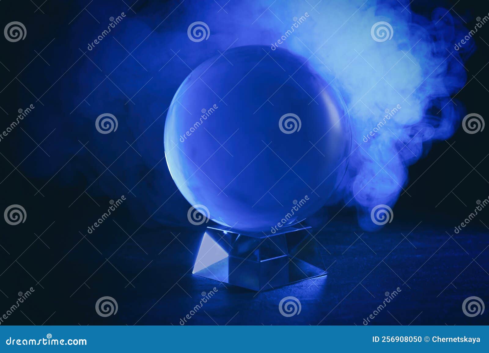 Magic Crystal Ball on Table and Smoke Against Dark Background. Making ...