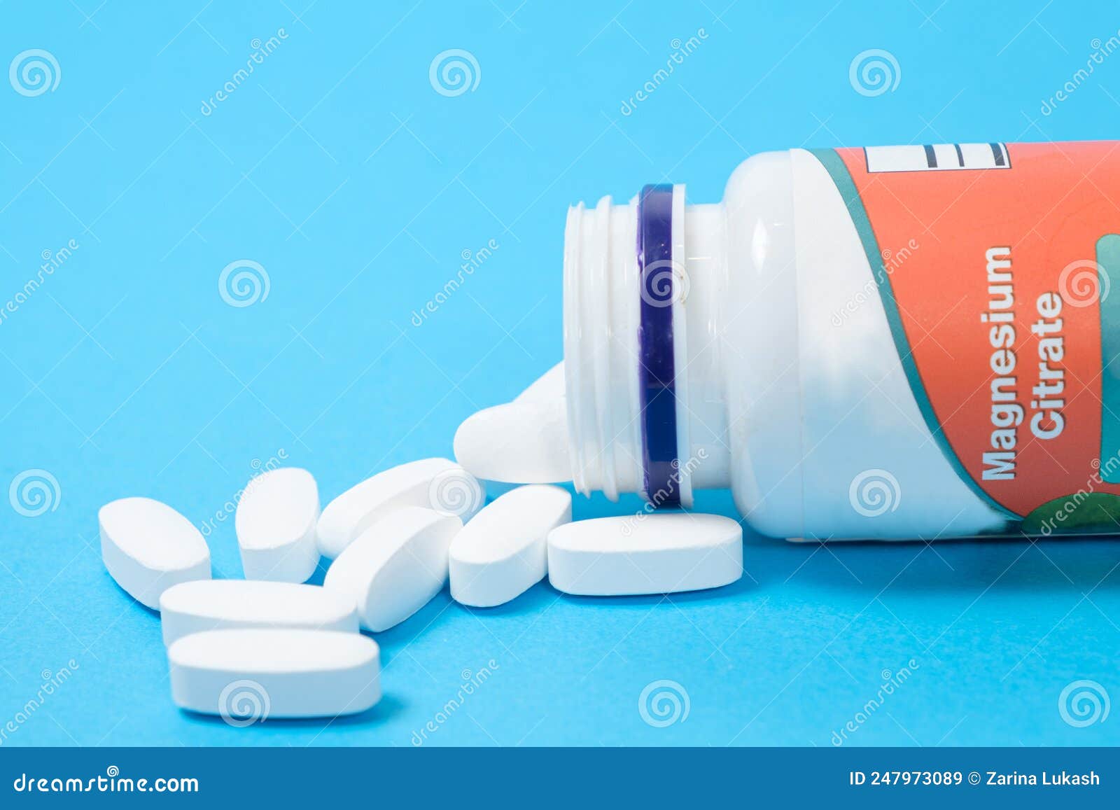 Magnesium Citrate Pills Spill Out of a Jar on a Blue Background. Stock ...