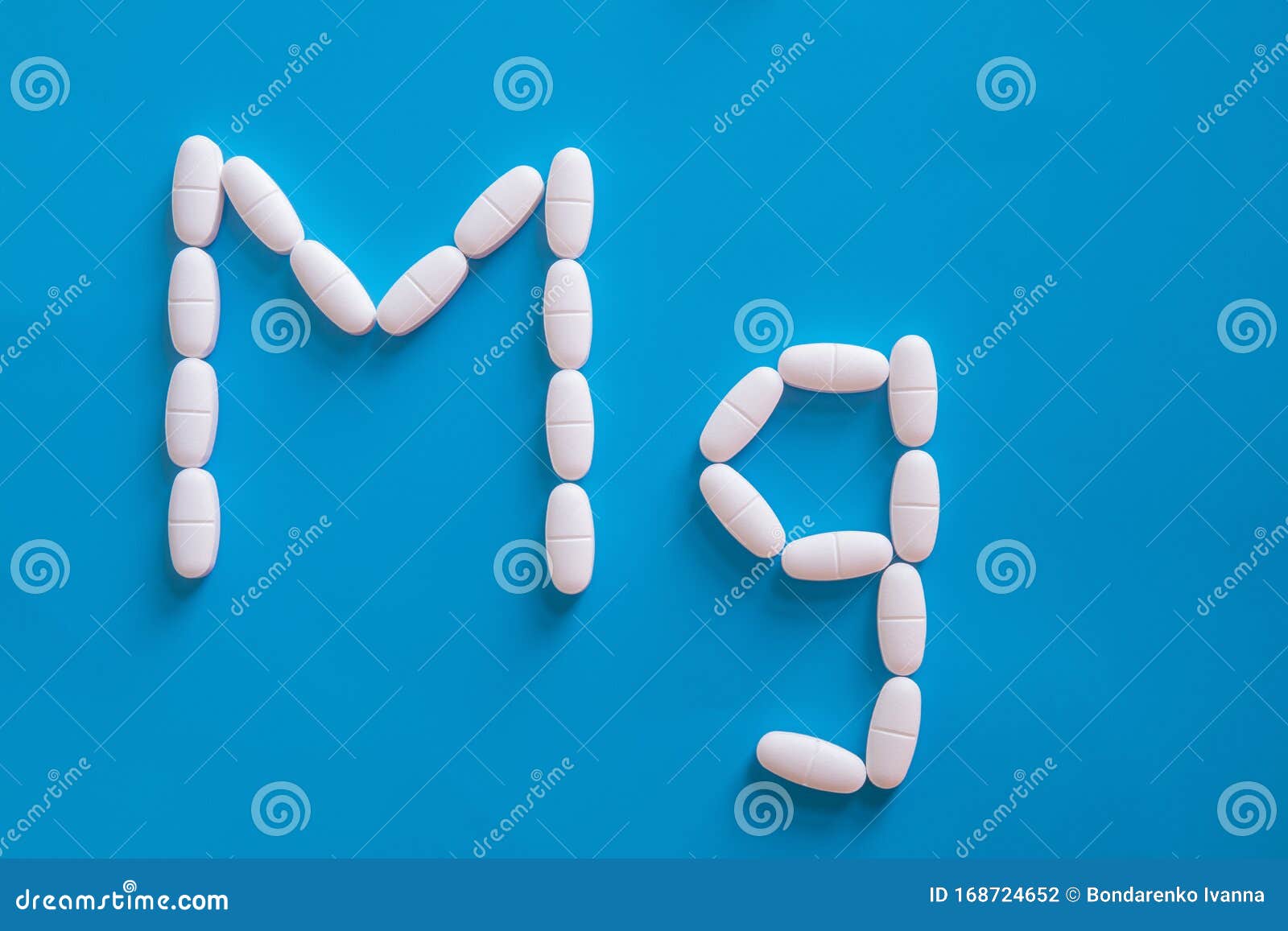 Magnesium Tablets in a Shape of Mg Element on Blue Background Stock ...
